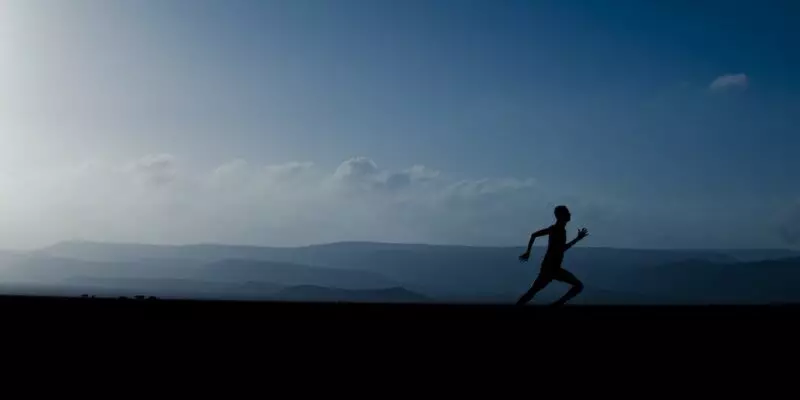 De pijnlijke taal van het lichaam van een ultraloper op een zinderende dag